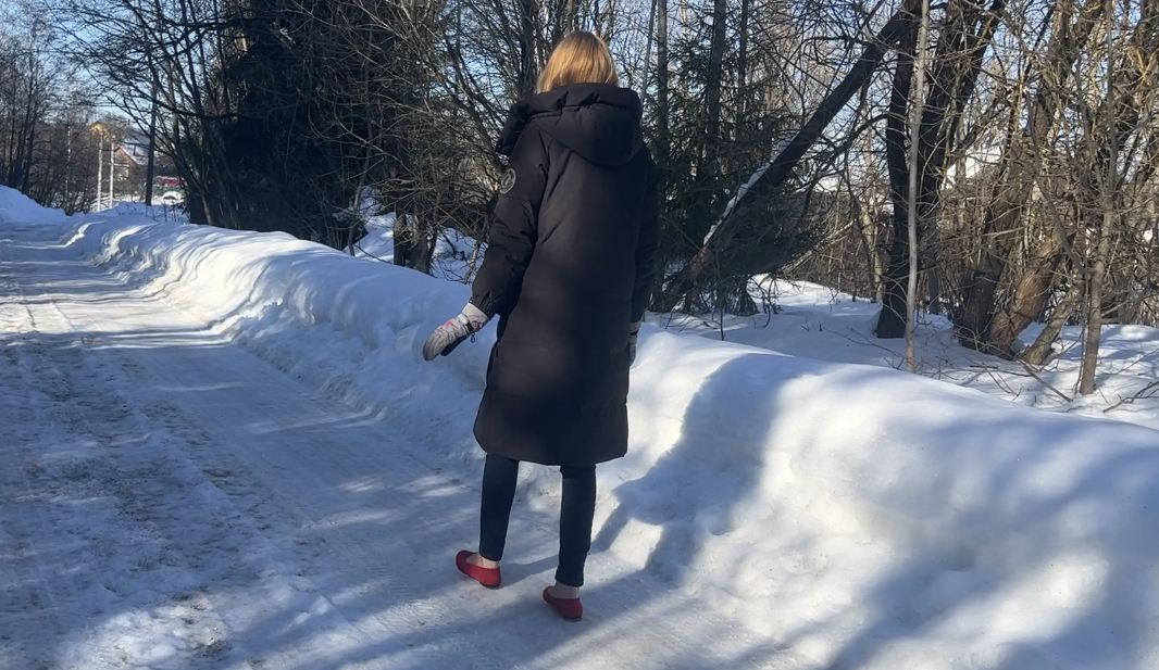 girl in ballet shoes slides on an icy road, the flat sole of the ballet ...